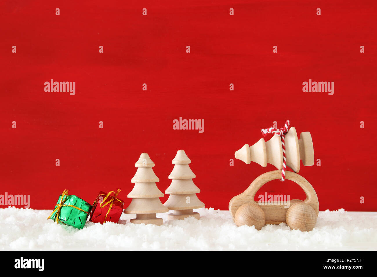 Wooden car carrying a christmas tree in front of red background Stock ...