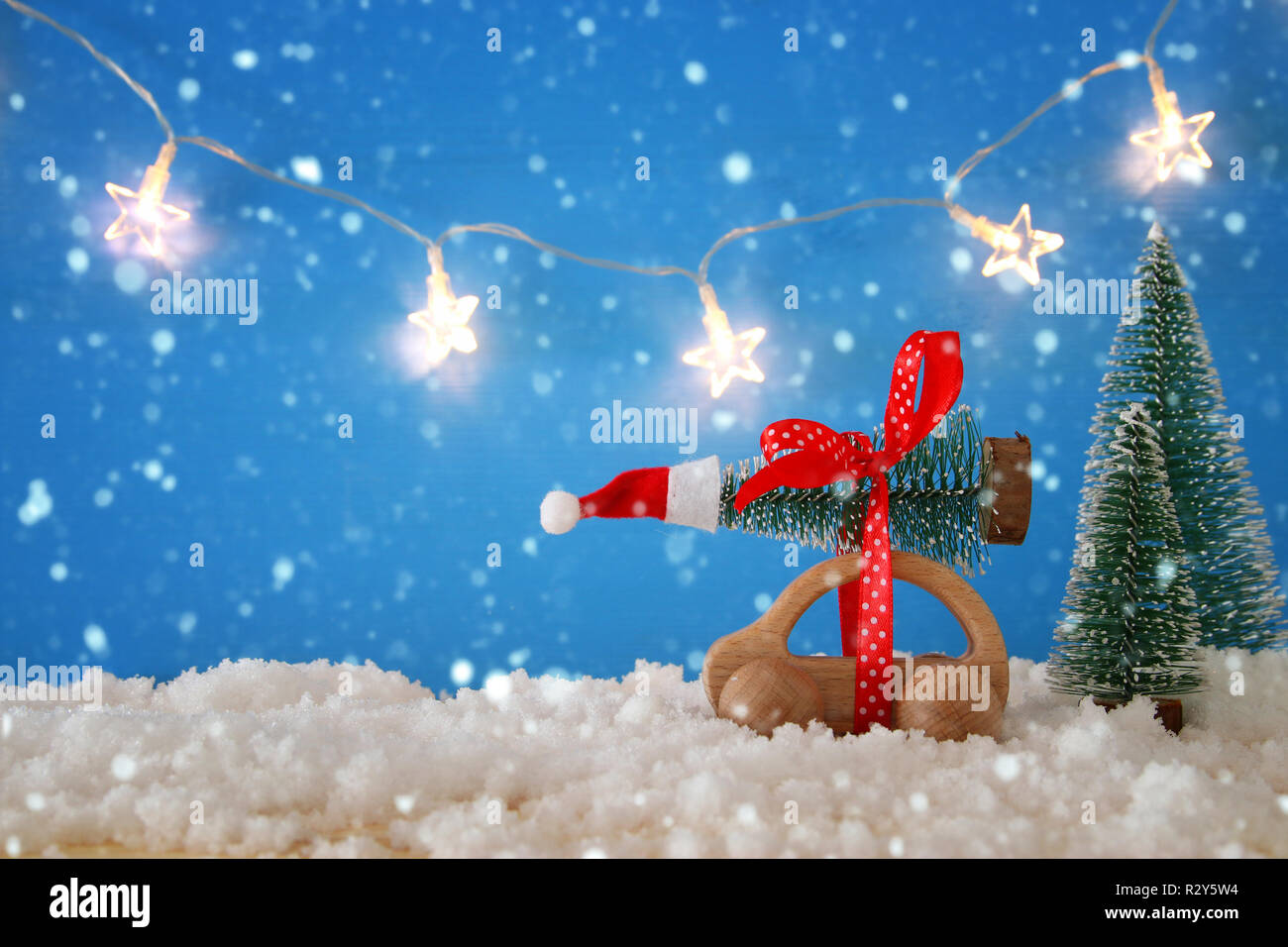 Wooden car carrying a christmas tree in front of blue background Stock ...
