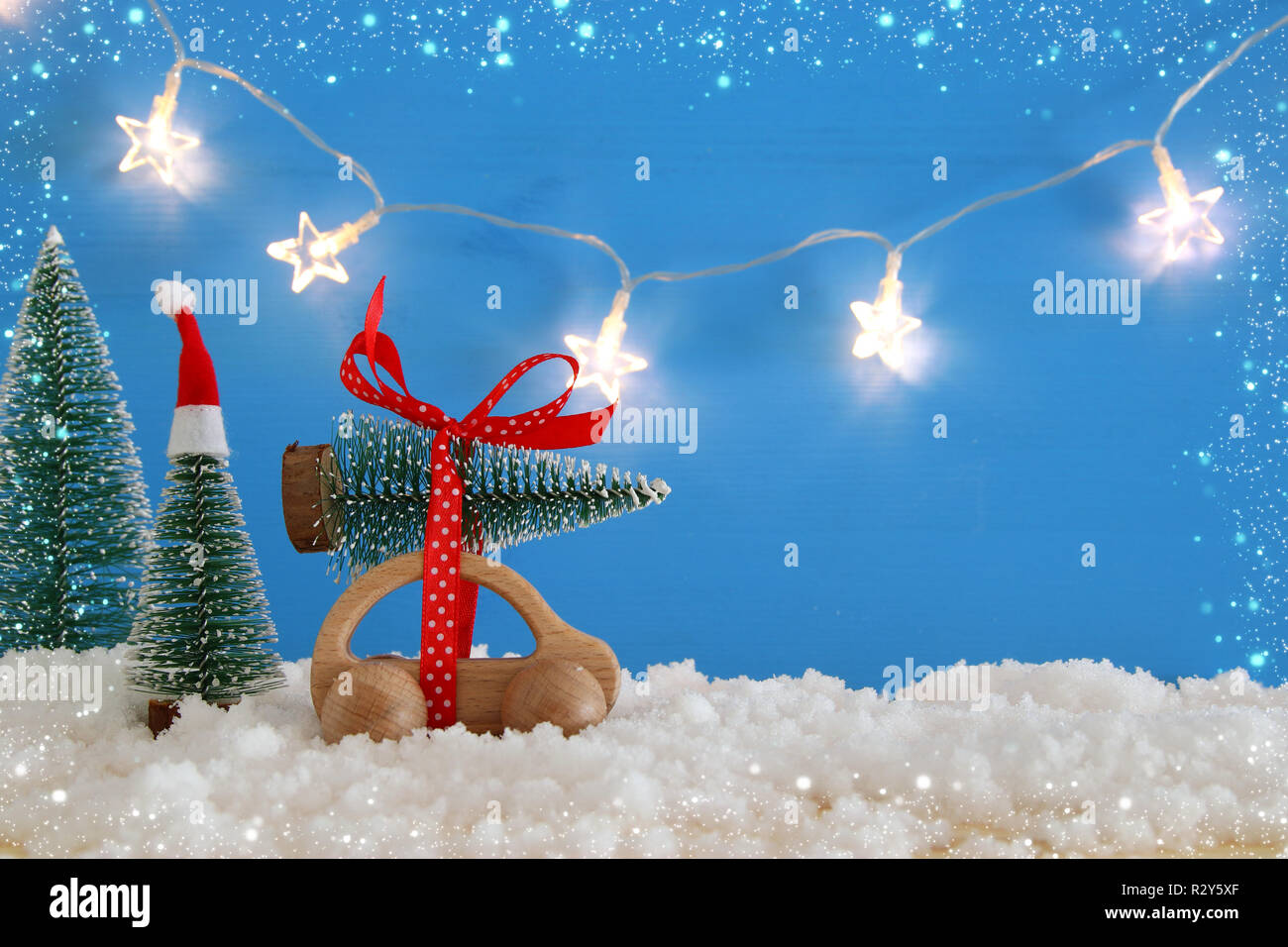 Wooden car carrying a christmas tree in front of blue background Stock ...