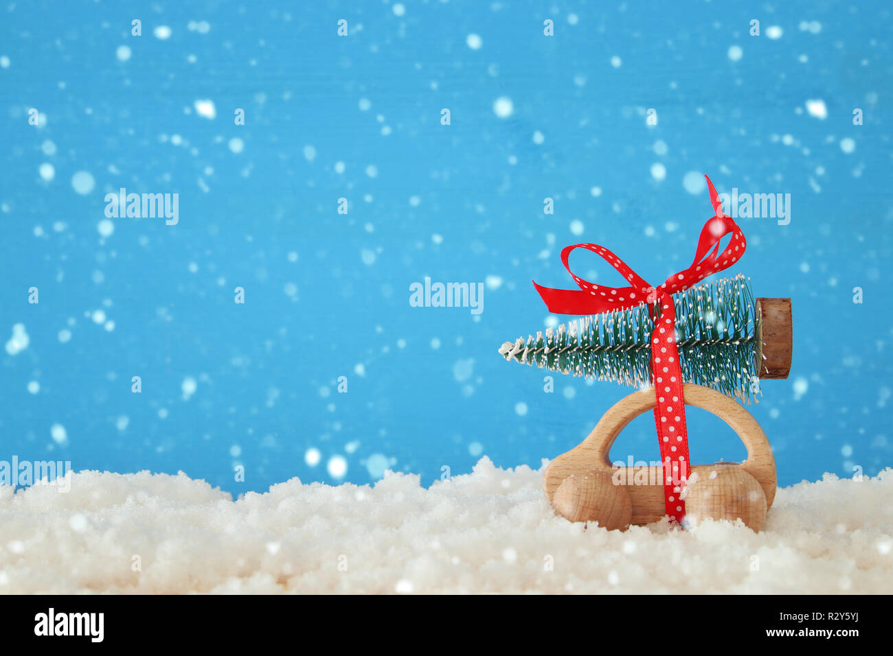 Wooden car carrying a christmas tree in front of blue background Stock ...