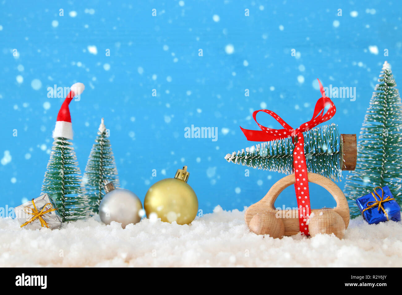 Wooden car carrying a christmas tree in front of blue background Stock ...