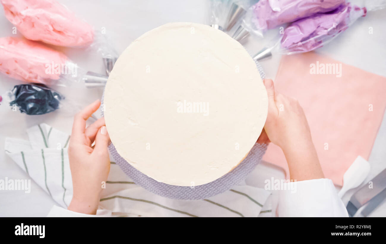 Flat lay. Frosting pink and purple cake with a white buttercream icing ...