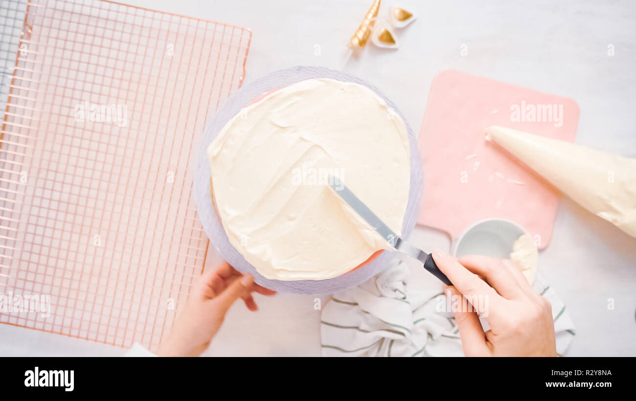 Flat lay. Frosting pink and purple cake with a white buttercream icing ...