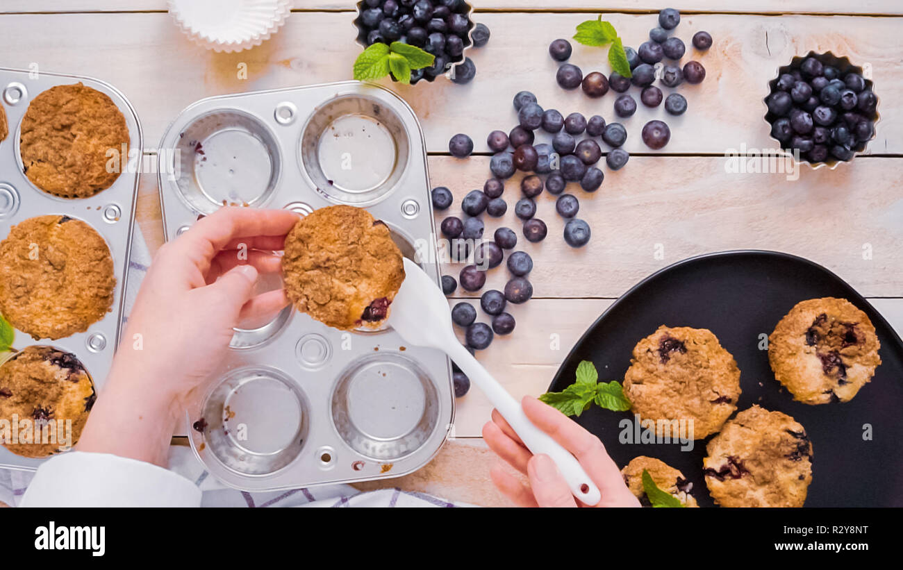 Taking blueberry muffins out of metal muffin pan Stock Photo - Alamy
