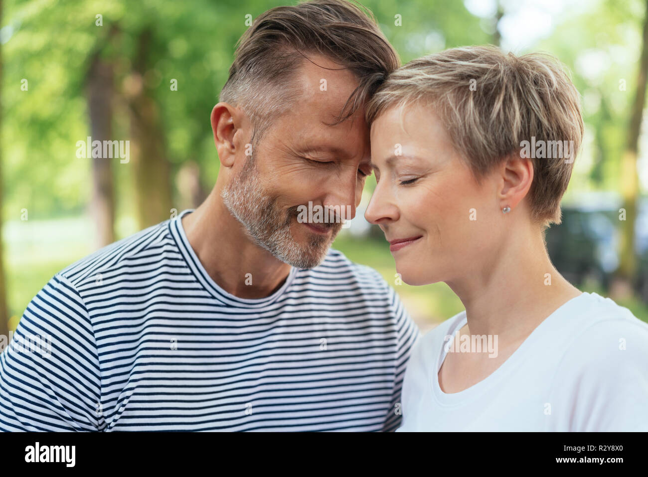 Affectionate Middle Aged Couple Touch Foreheads With Closed Eyes And