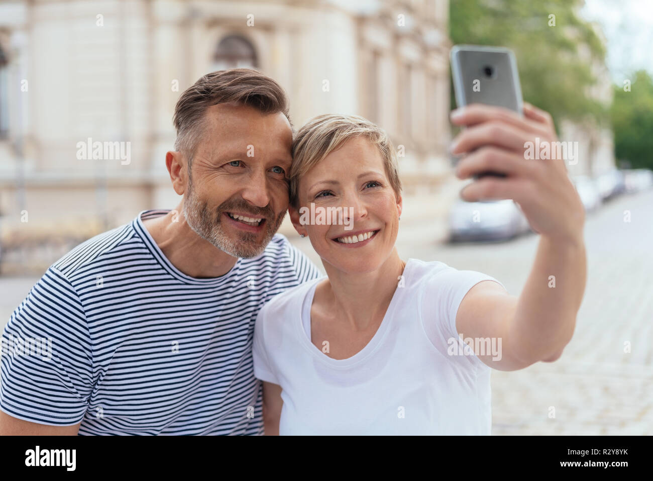 Happy Middle Aged Couple Posing For A Selfie With Their Cheeks Touching
