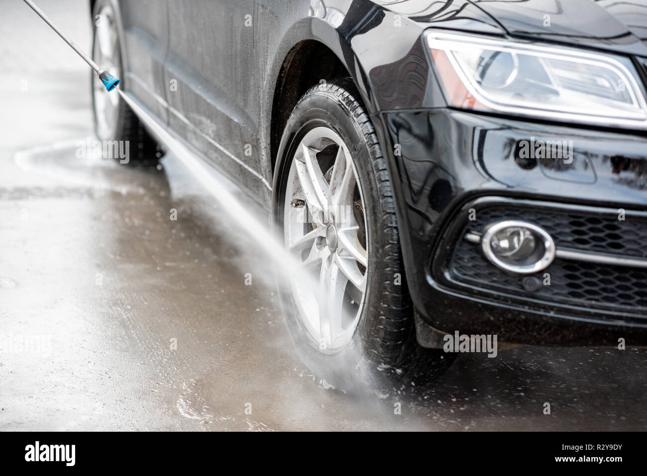 Close-up of a car under the water jet during the washing process on a ...