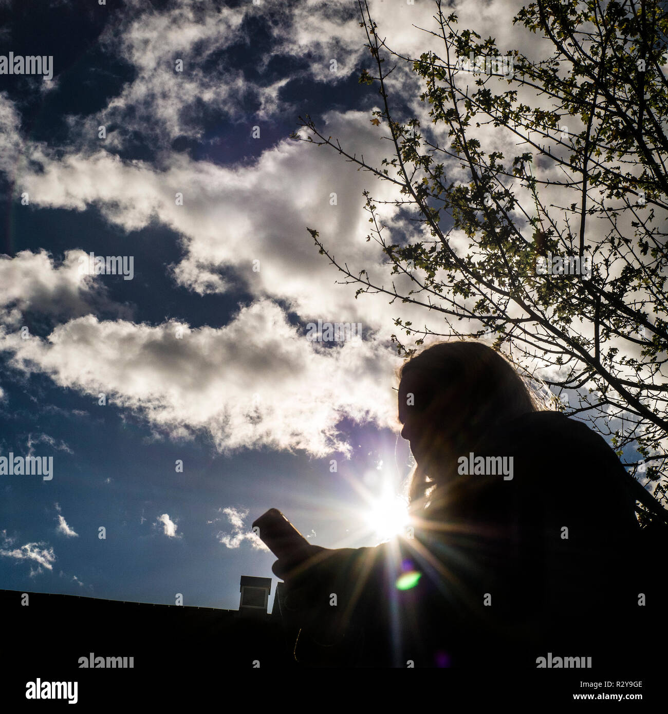 silhoette of figure with sun and clouds behind Stock Photo - Alamy