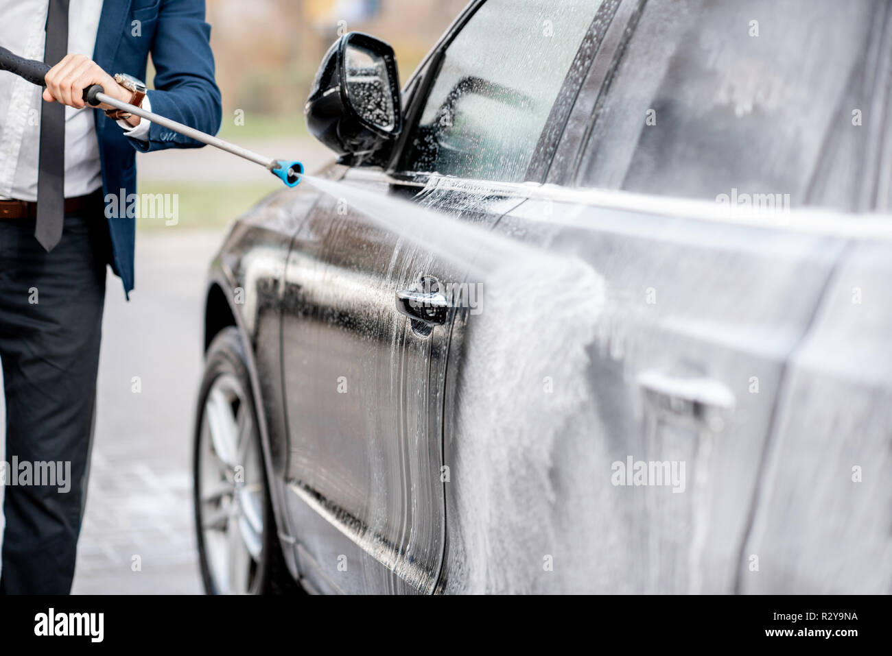 Close-up of a car under the water jet during the washing process on a ...