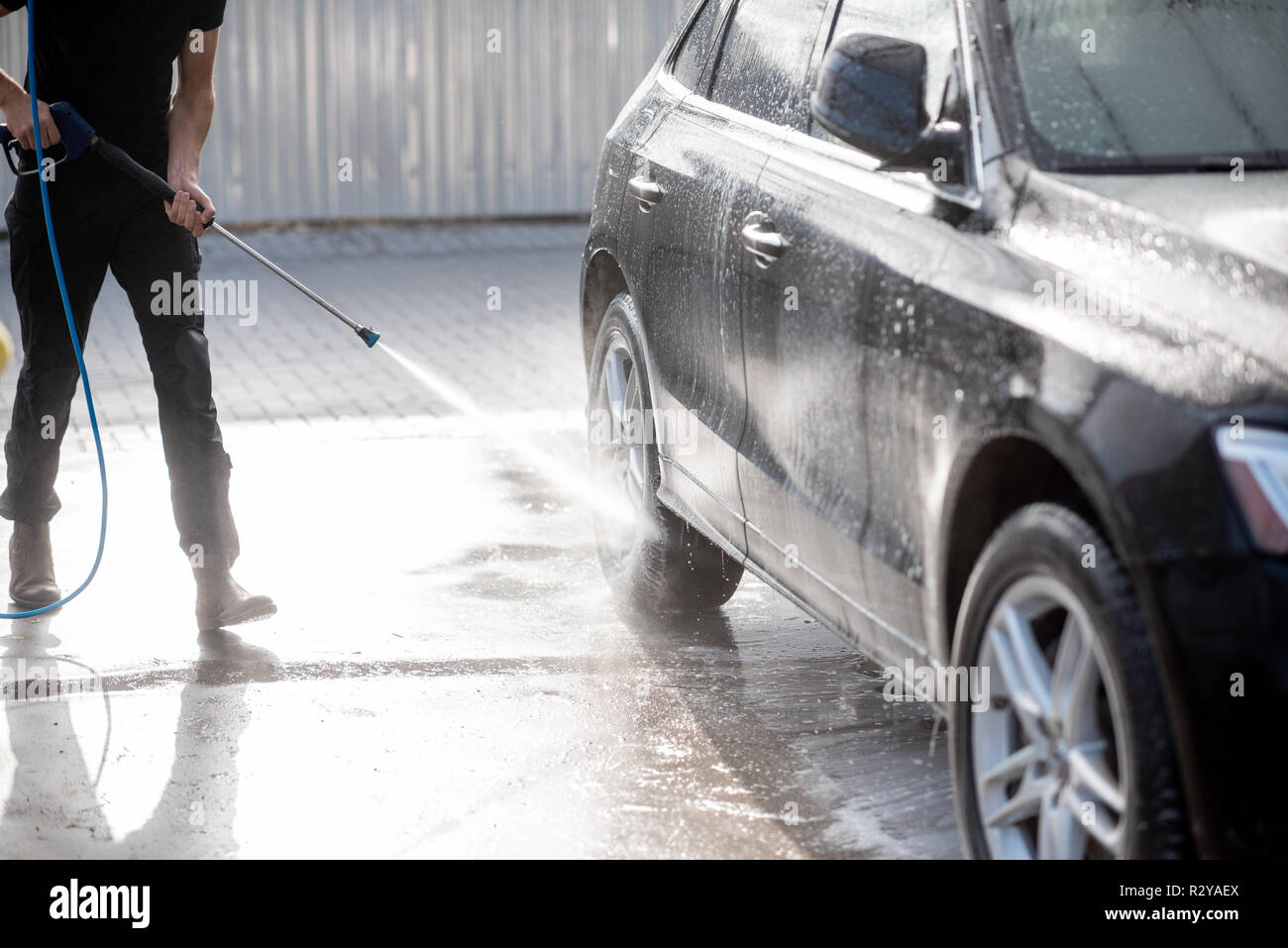Close-up of a car under the water jet during the washing process on a ...