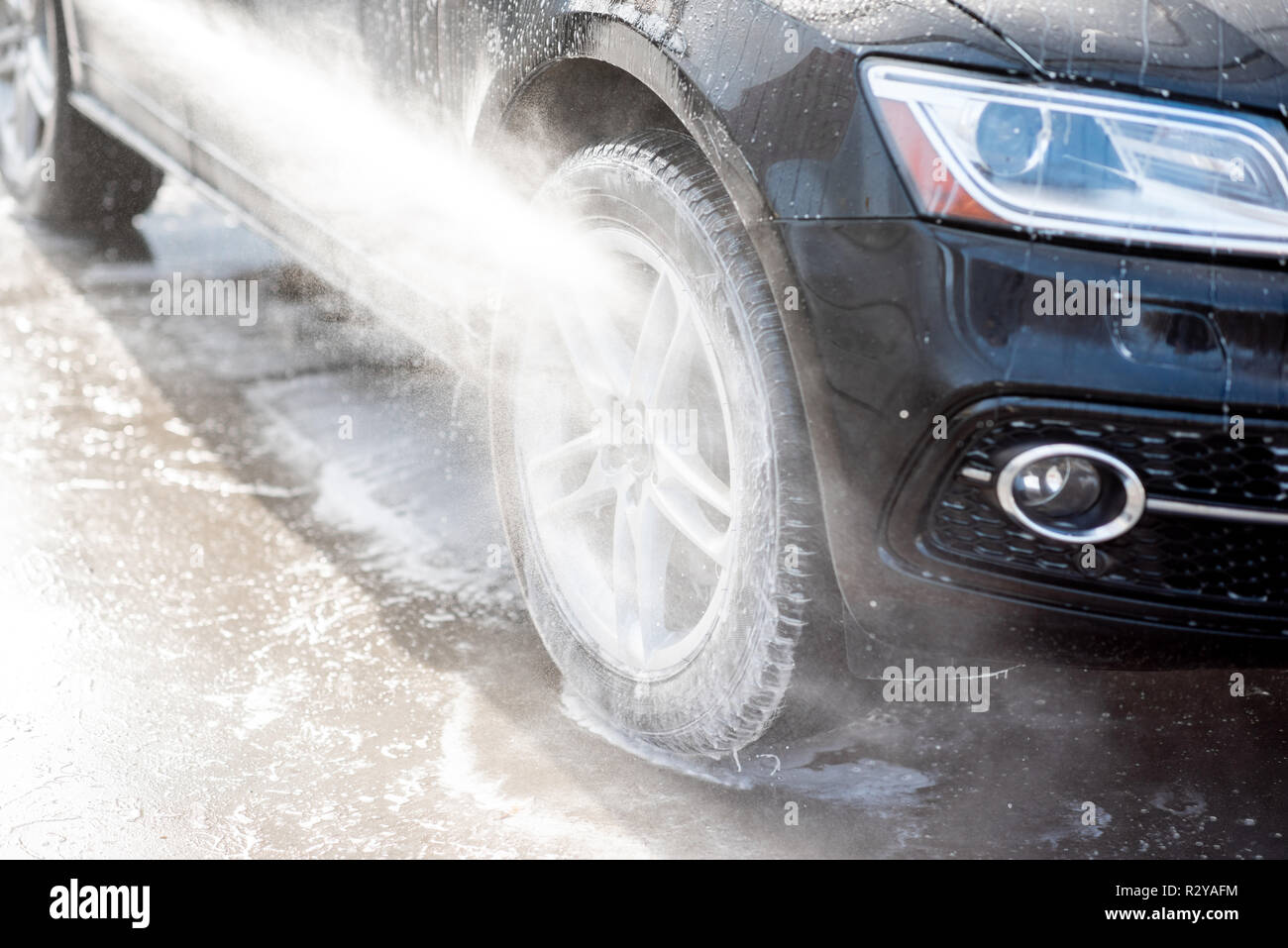 Close-up of a car under the water jet during the washing process on a ...
