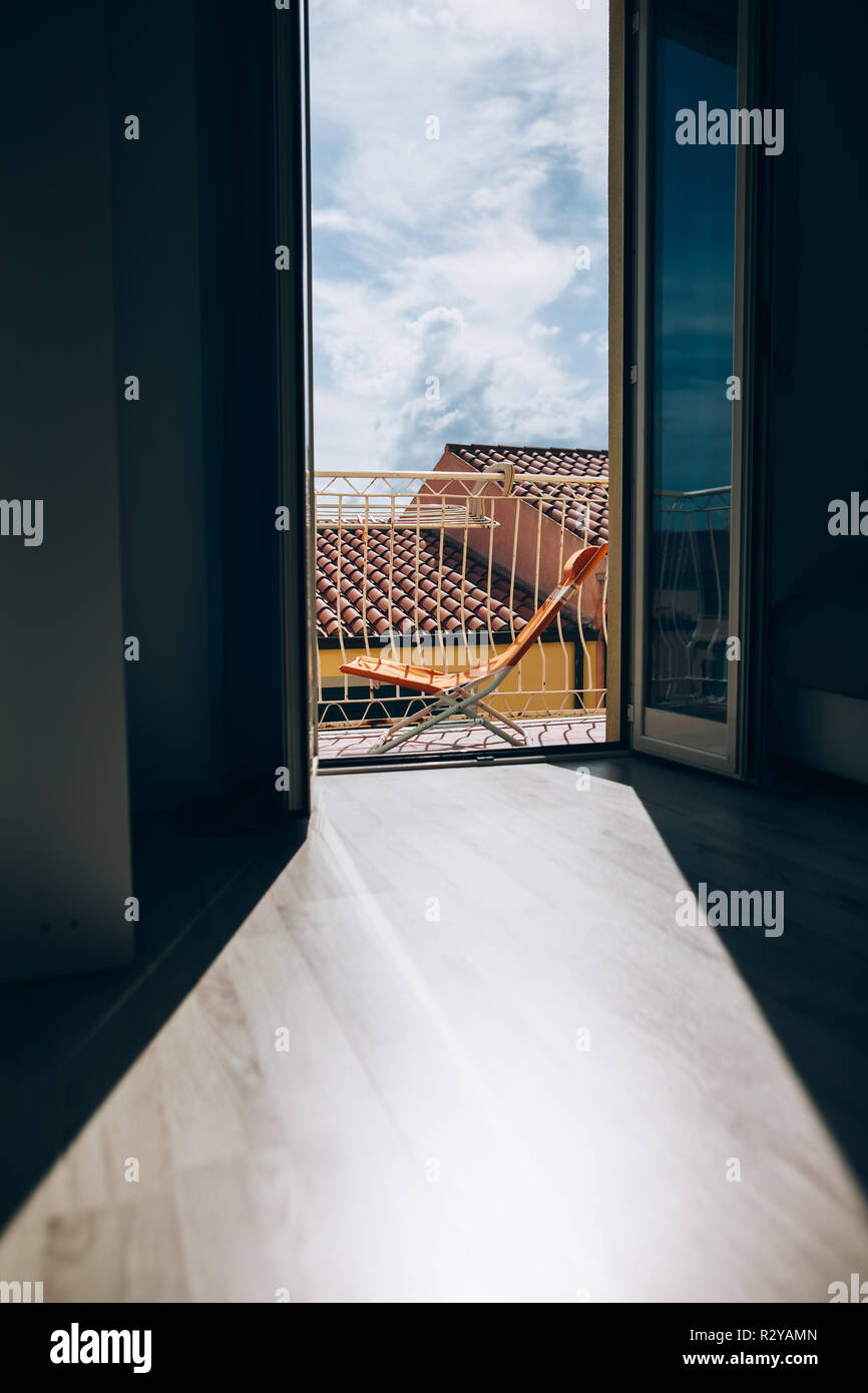Open window with city roofs view in Italy. Light and shadow in room ...
