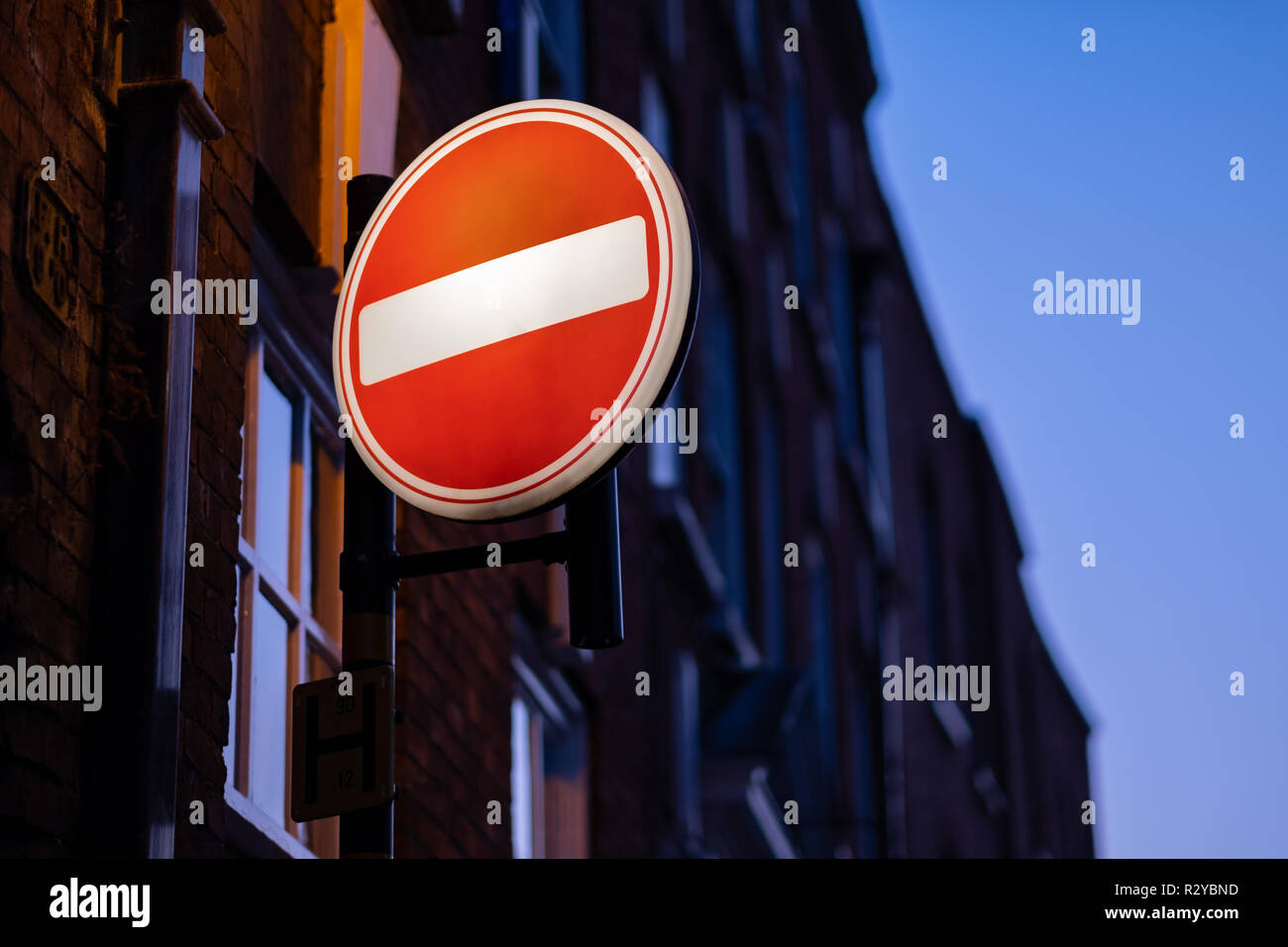 Illuminated no entry sign at dusk in winter UK Stock Photo - Alamy