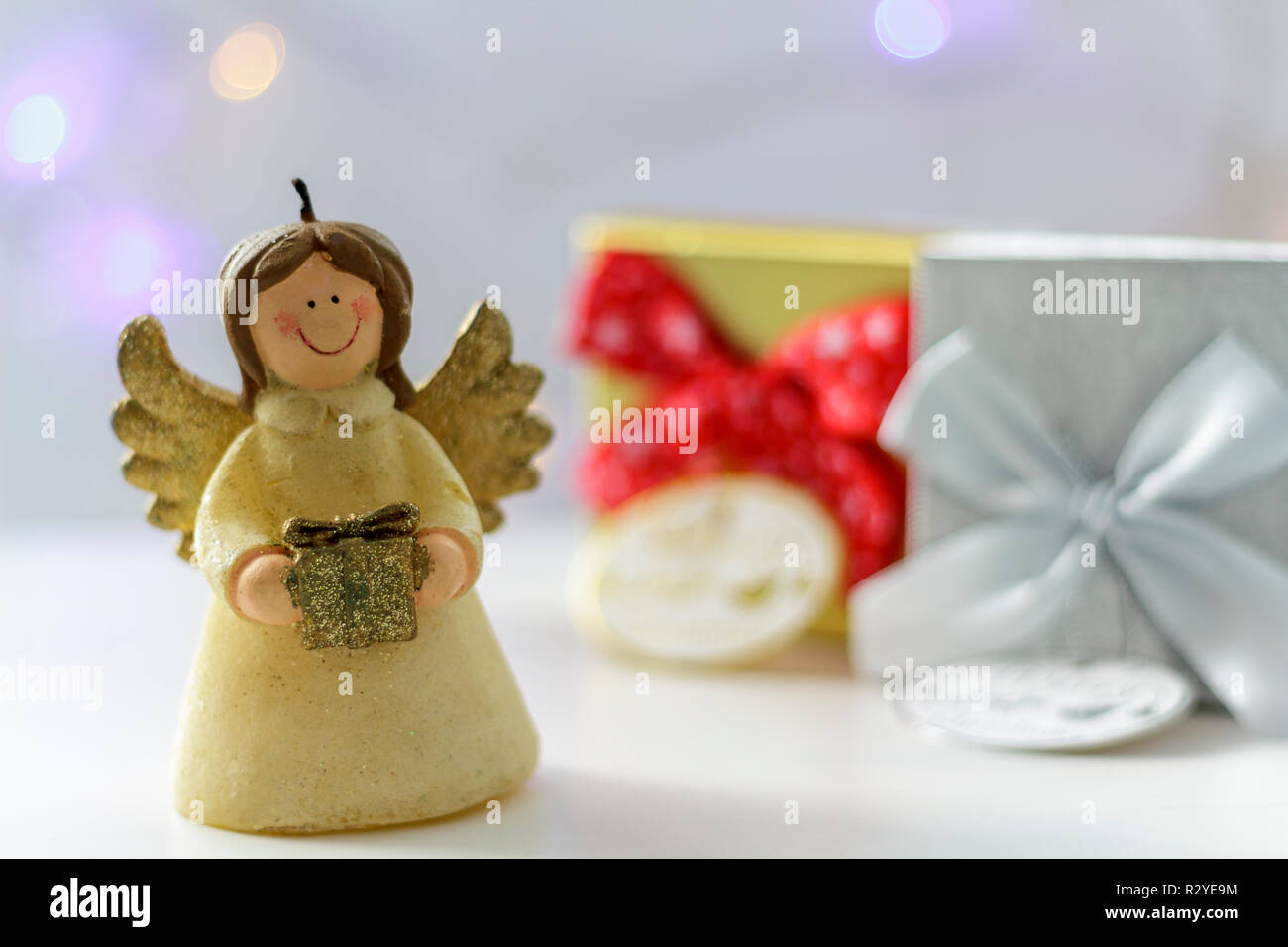 Christmas angel with gift boxes and christmas lights on the background ...
