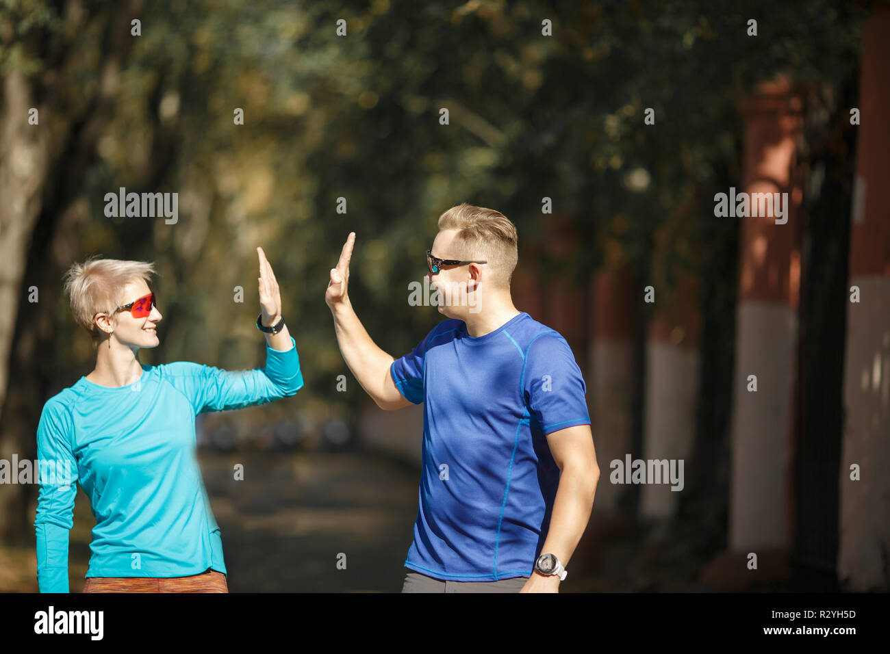Portrait of sporting man and woman doing handshake on morning jog in ...