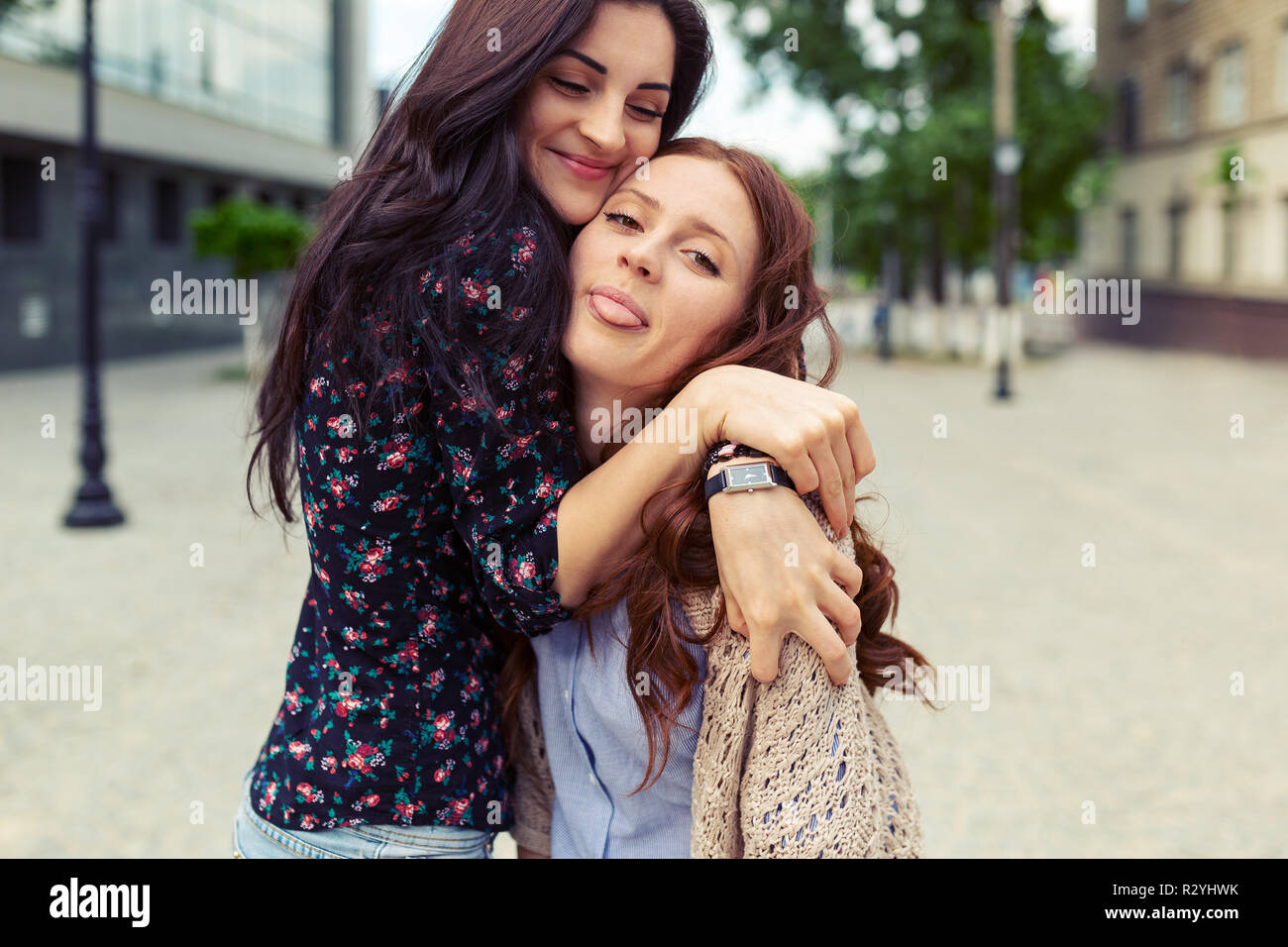 Portrait of carefree smiling sisters hugging and having fun together ...