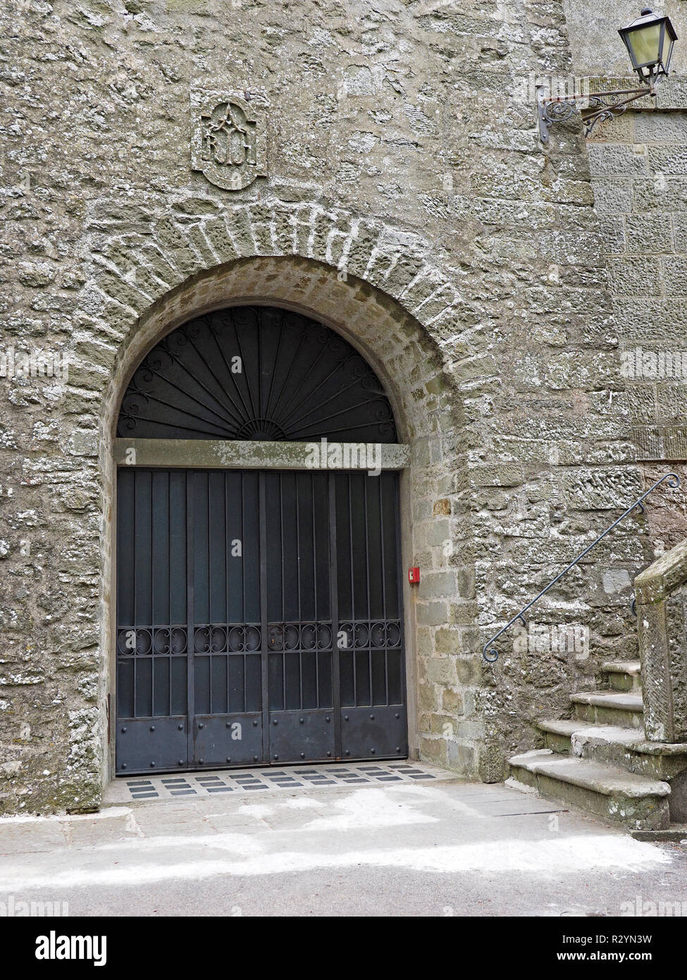 lantern above ancient arched doorway in massive stone wall with ...