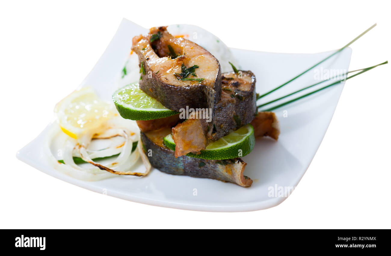 Plate of roasted red fish steaks served with rice with greens. Isolated ...