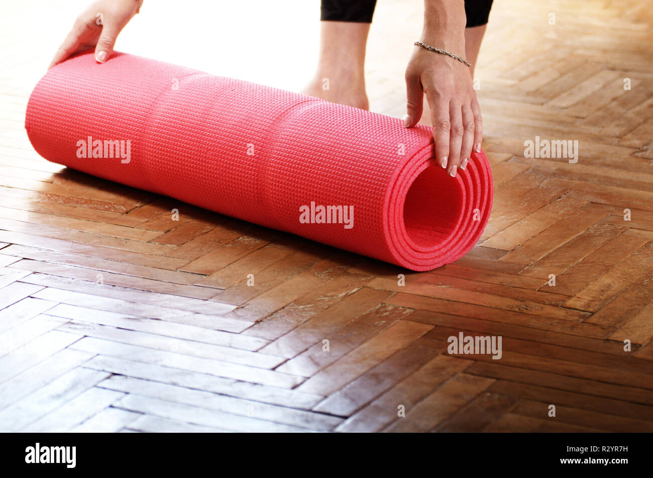 Female hands unrolling yoga mat before workout exercise. Healthy ...