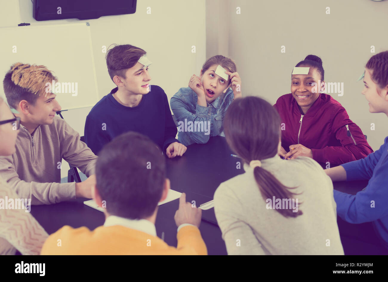 happy classmates having round of guess-who game during class Stock ...