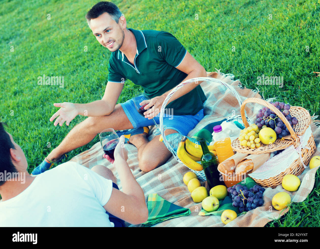Happy smiling man enjoying life on picnic outdoors with his friend ...