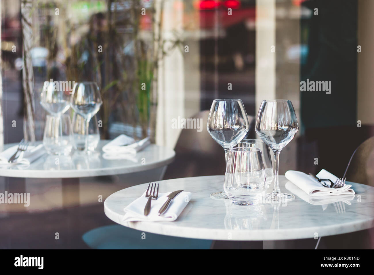 Table setting in a French restaurant for two. View through a window ...
