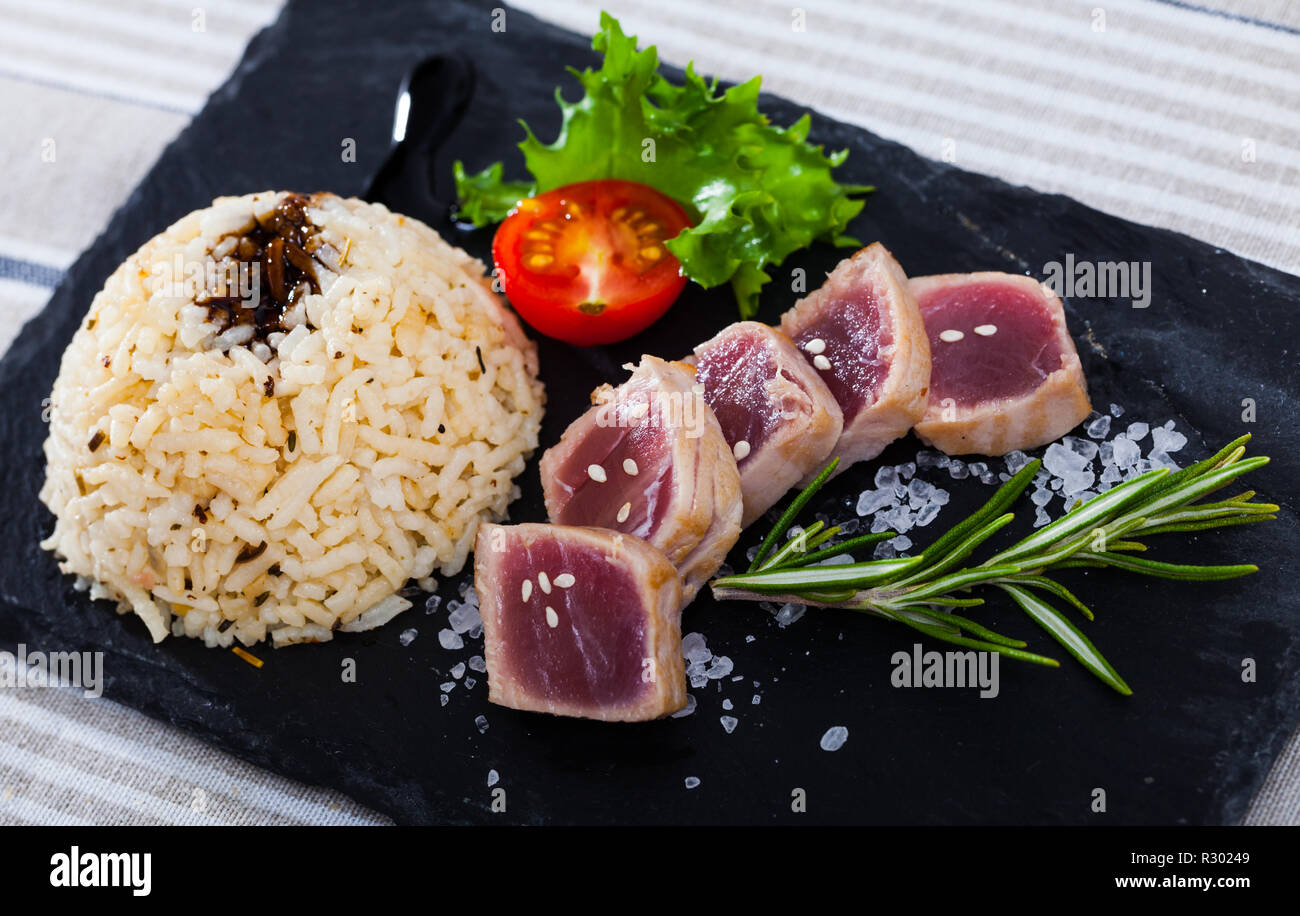 Lightly seared tuna tataki steak with garnish of steamed rice and ...