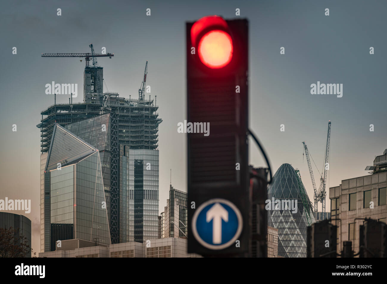 Red Traffic light with tall city buildings and construction site in the ...
