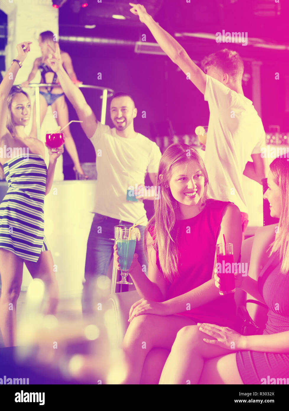 Happy cheerful positive females talking on party in the club with ...