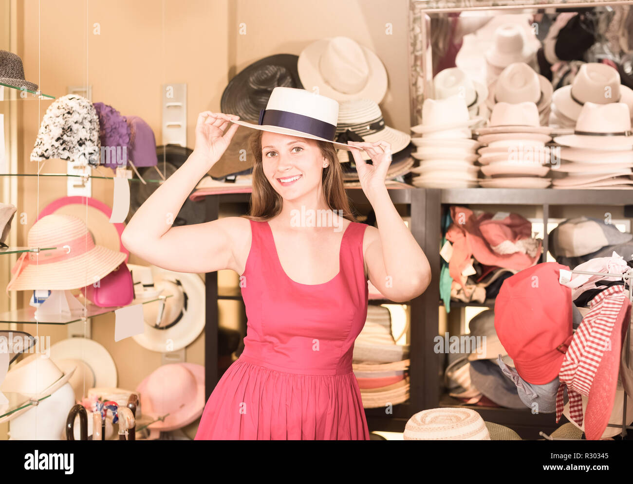 adult girl try on floppy hat from the range in store Stock Photo - Alamy