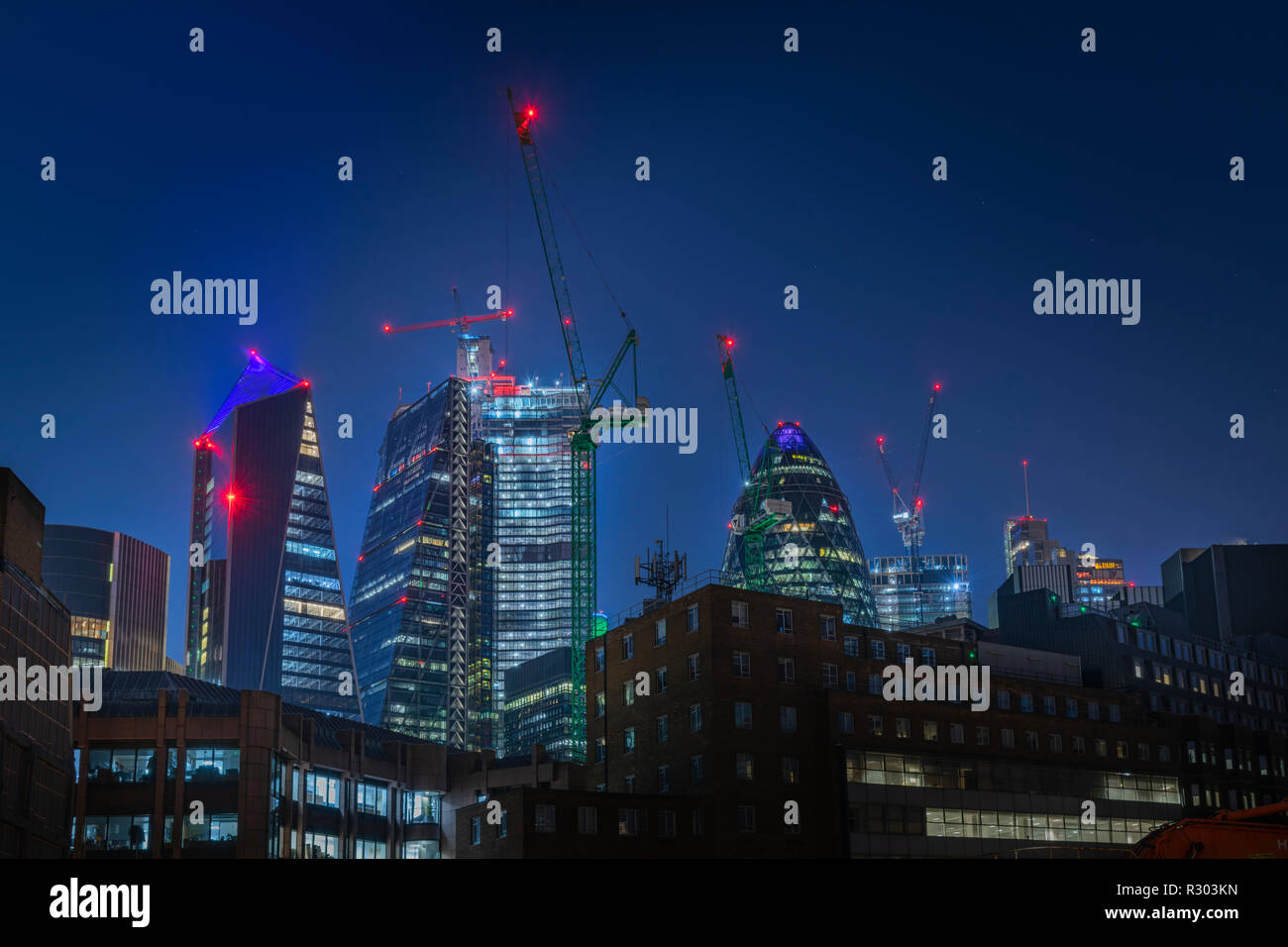 Iconic tall buildings in the City of London at night. The Skyline shows ...