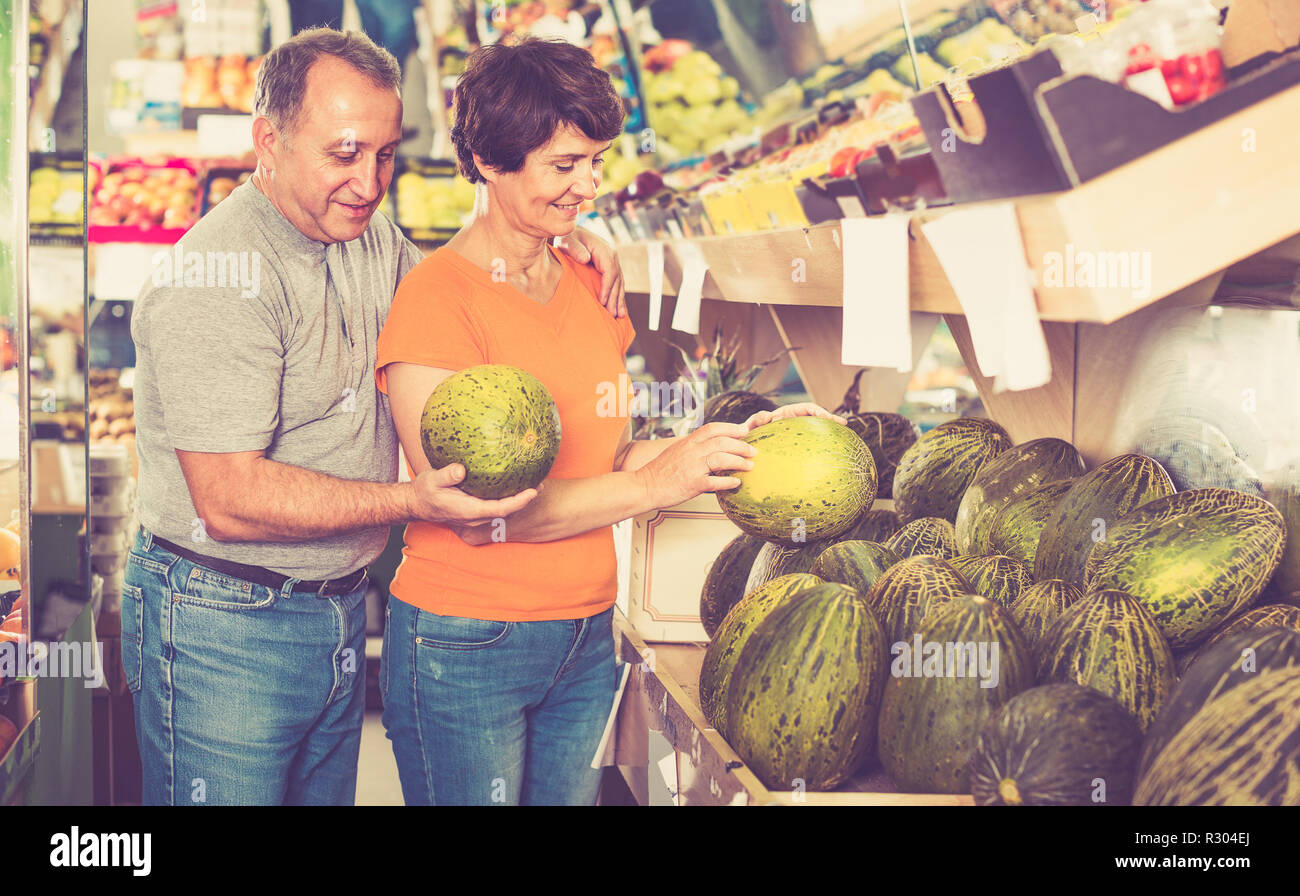 Nice man and his wife are choosing ripe melon in the fruit store Stock ...