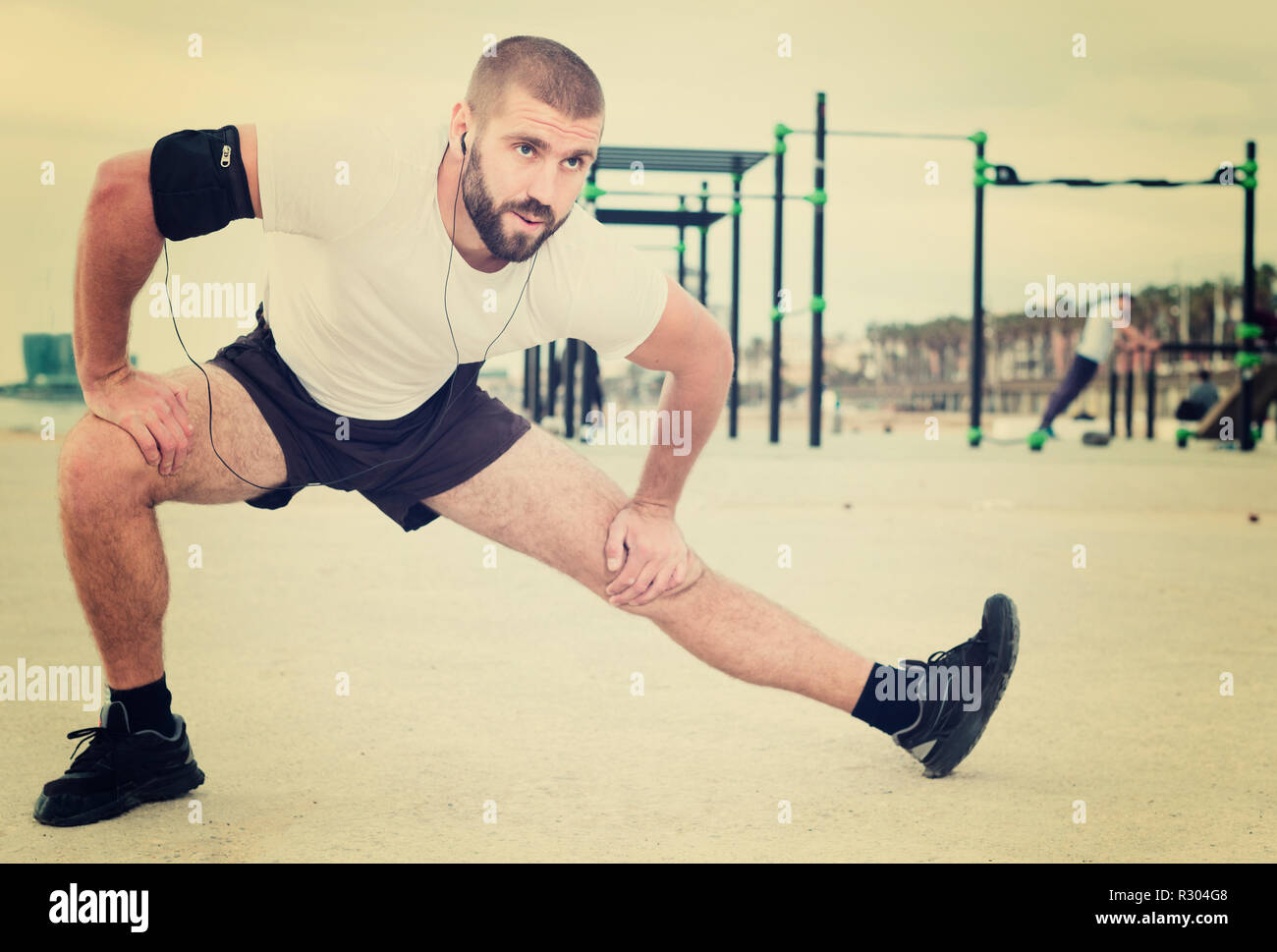 Young athletic man flexing his leg muscles before a long run Stock ...