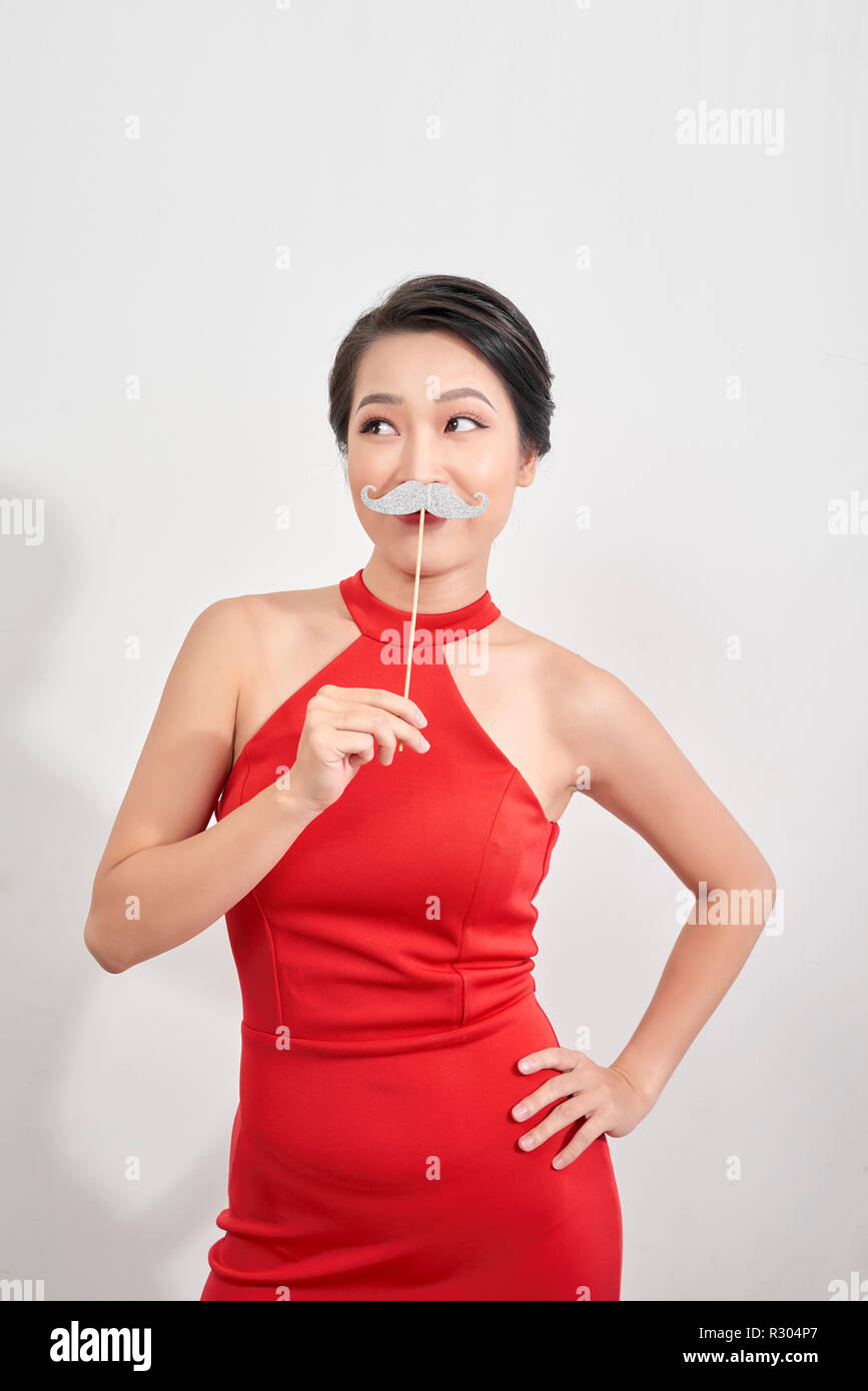 Surprised winking model Girl holding funny mustache on stick over white ...
