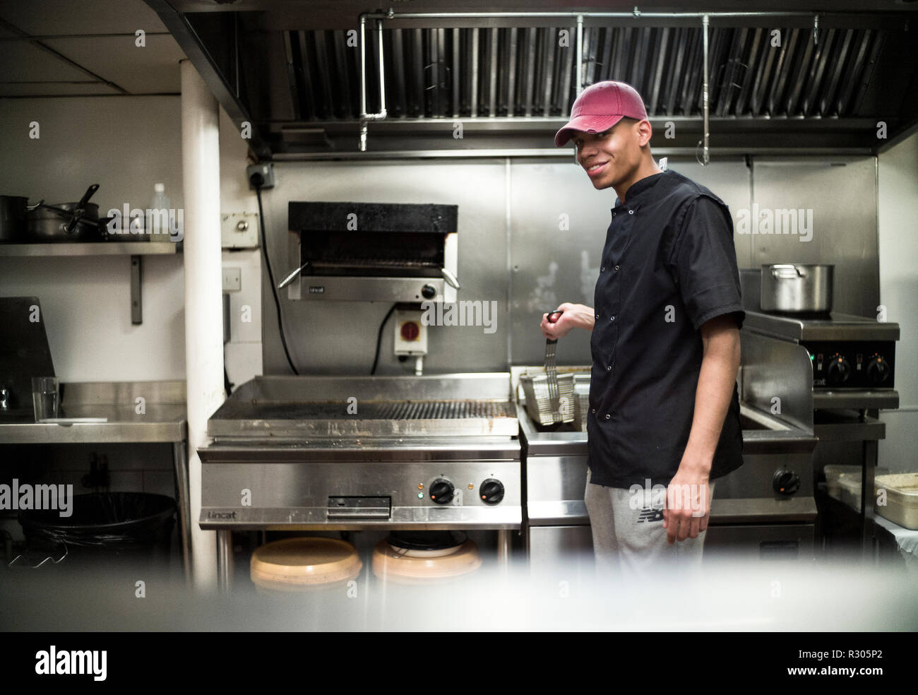 kitchen chef in red baseball hat smiling at camera Stock Photo - Alamy