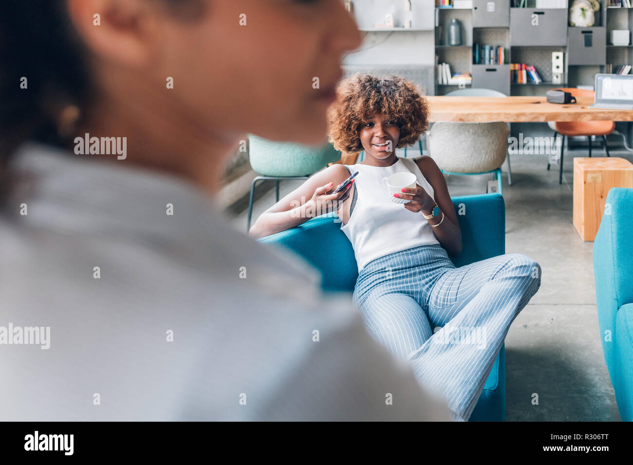 two young women indoor drinking after work - celebrating success, after ...