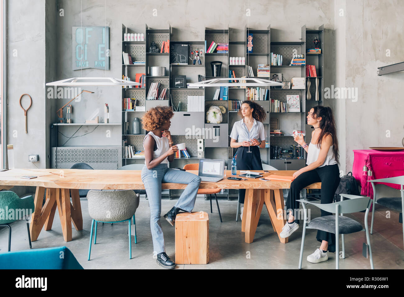 Three young women indoor drinking after work - celebrating success ...