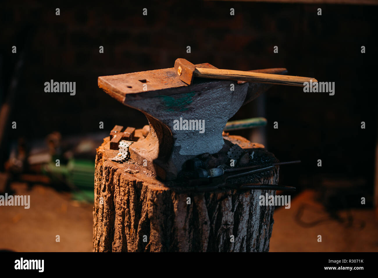 An old anvil attached to a wooden base stands in a private blacksmiths ...