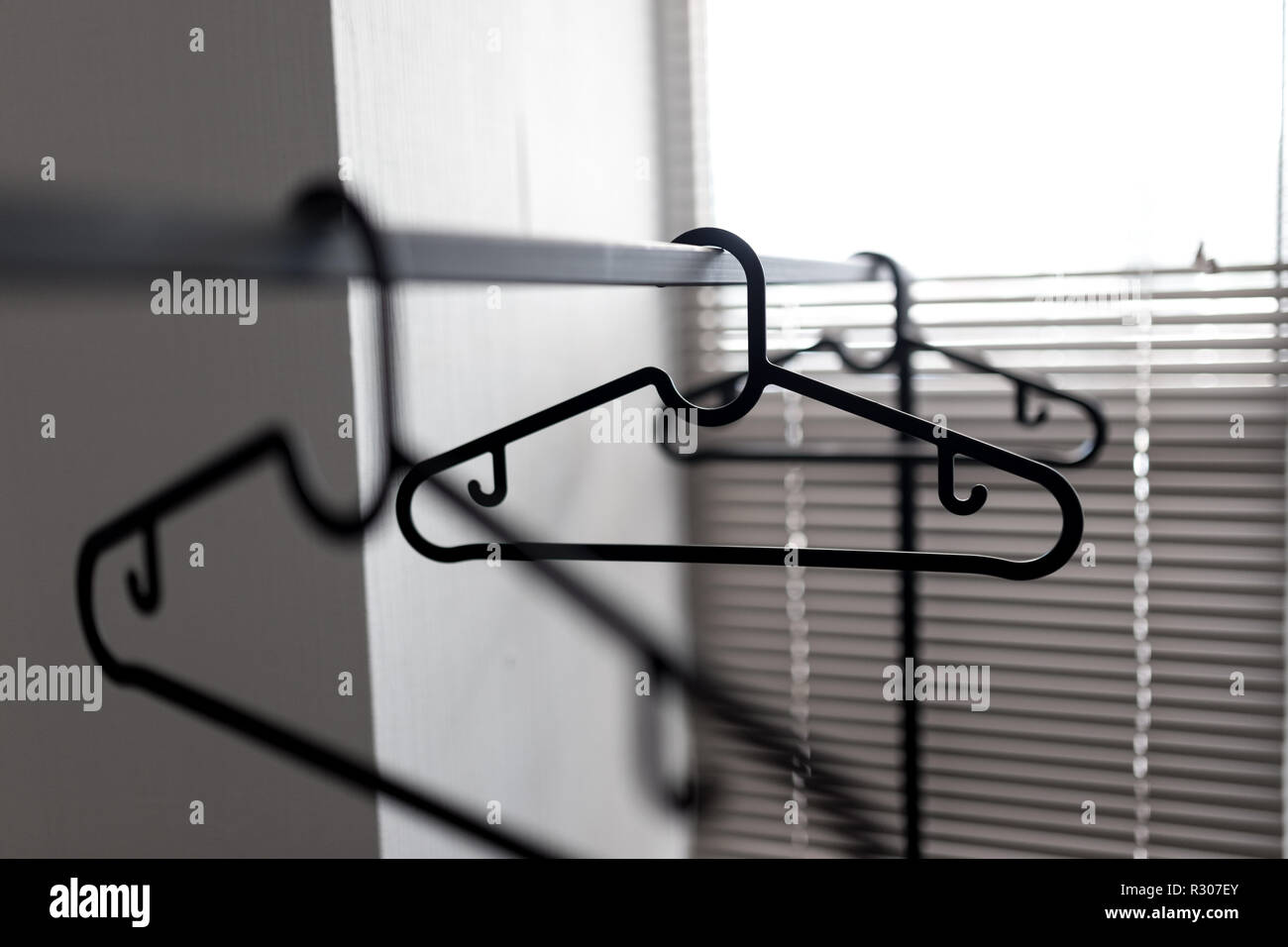 Simple metal clothing rail with empty coat hangers. Shop or boutique ...