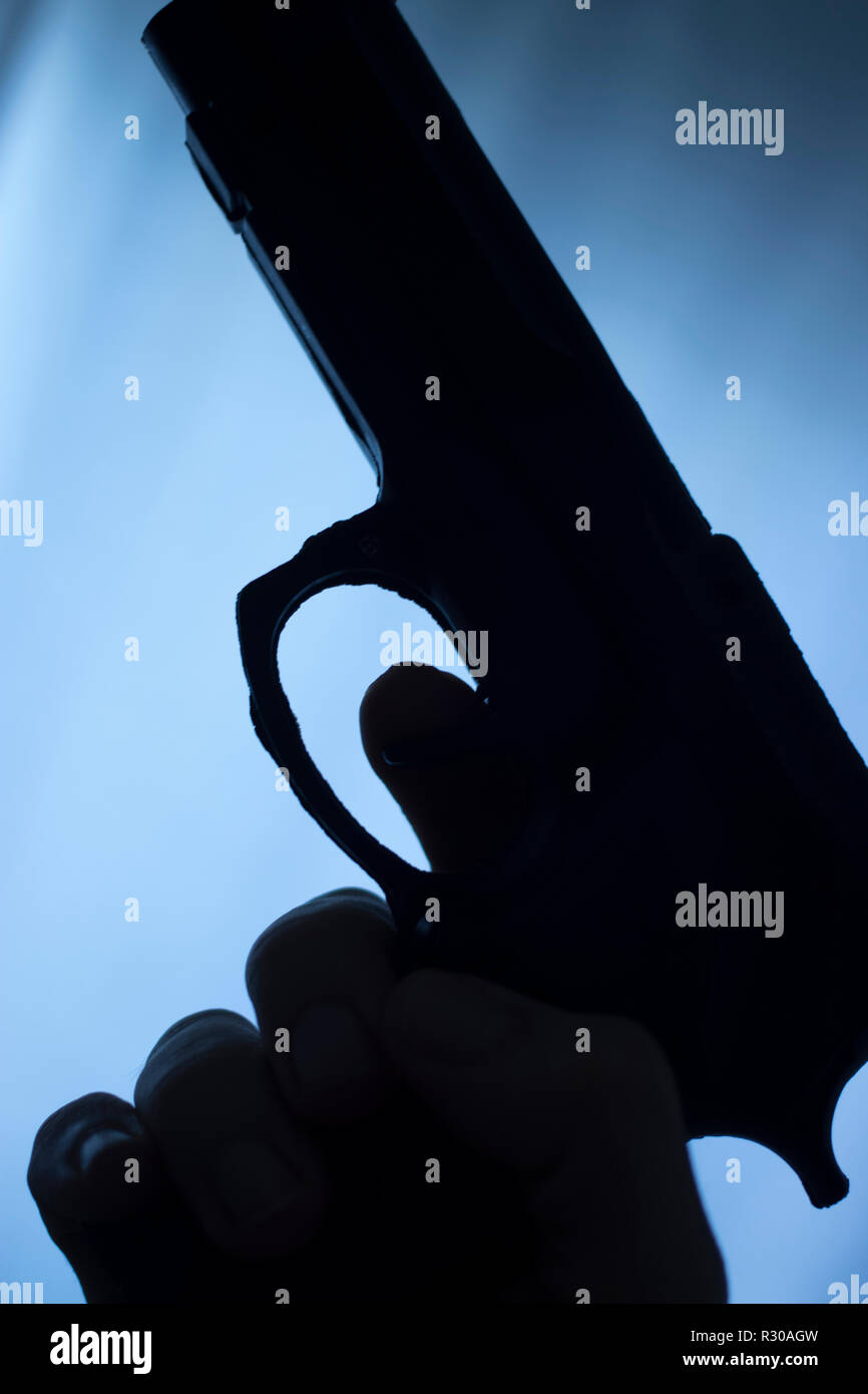 Pistol automatic handgun weapon in silhouette in hand of killer ...