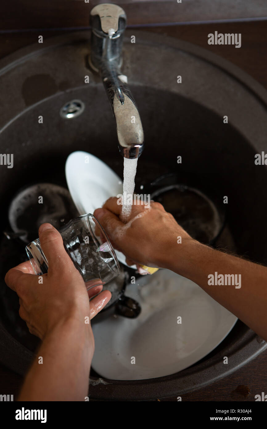 Picture from above of man's hands washing dish into sink Stock Photo ...