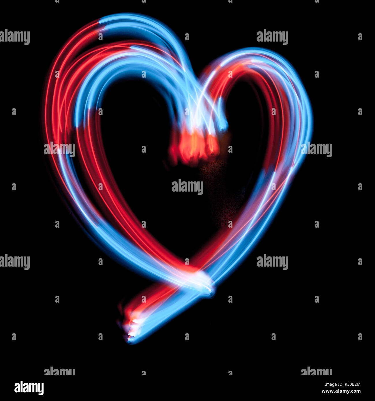 The heart-shaped digital neon lights are on the dark or black studio ...