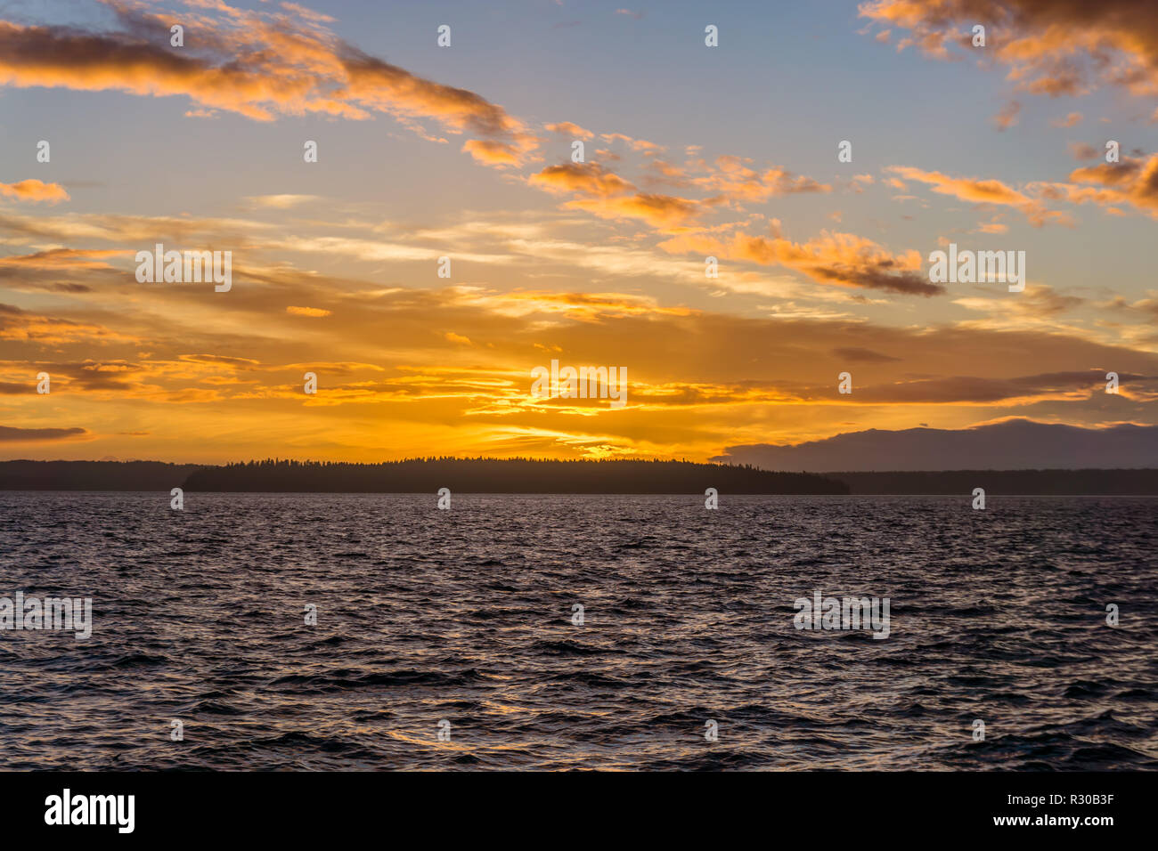 A view of a golden sunset across the Puget Sound from West Seattle ...