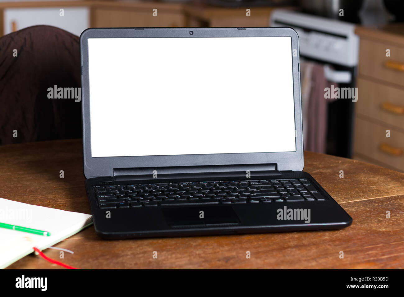 Laptop computer in vintage kitchen. Blank white screen ready for mockup ...