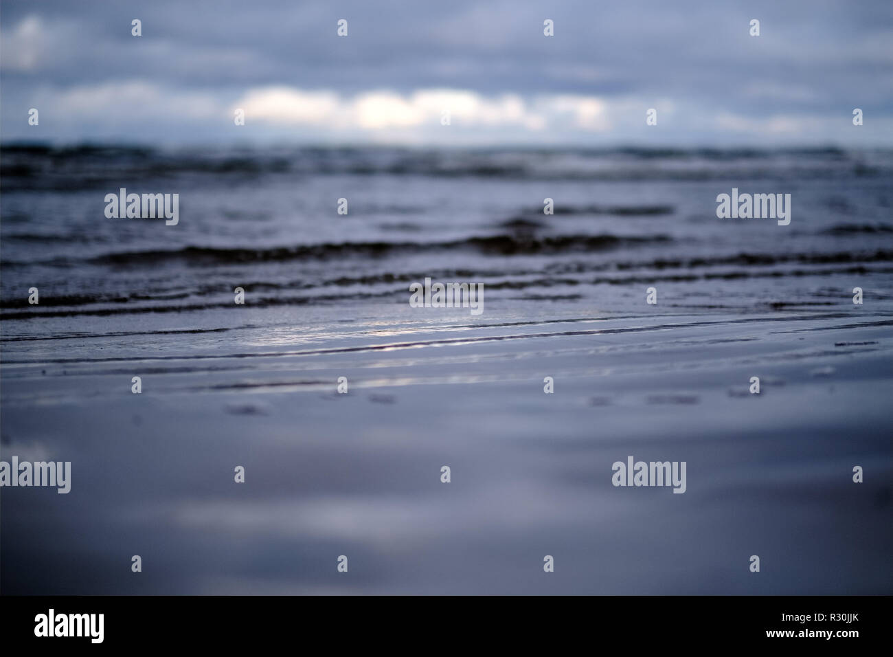 storm clouds over sea. small waves on clean white sand beach. shallow ...