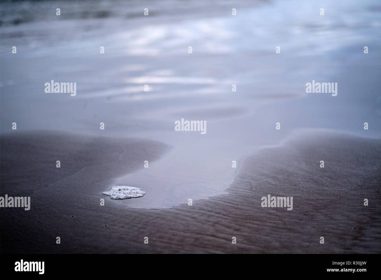 storm clouds over sea. small waves on clean white sand beach. shallow ...