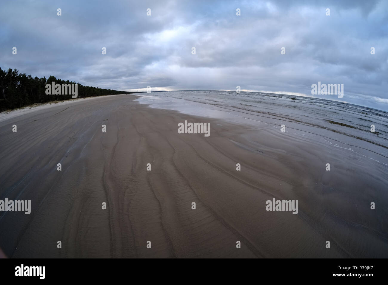 storm clouds over sea. small waves on clean white sand beach. shallow ...