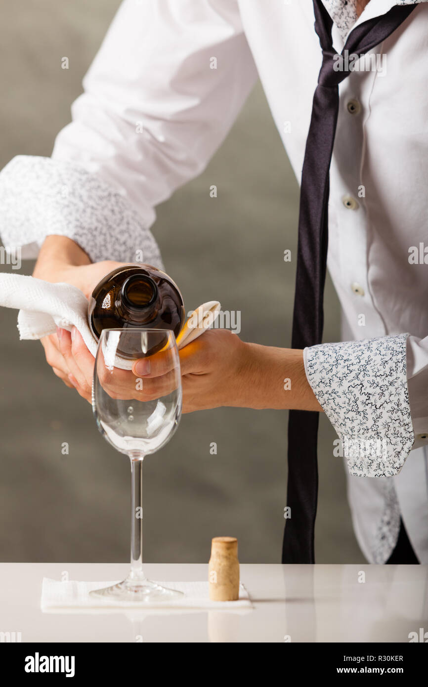 Male waiter or butler serving pouring wine into glass Stock Photo - Alamy