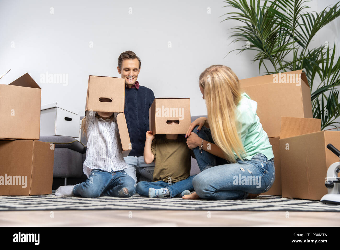 Picture of parents and children with cardboard boxes on their heads ...
