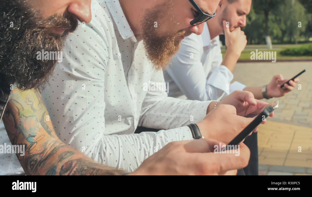 Three brutal bearded men use their phones Stock Photo - Alamy